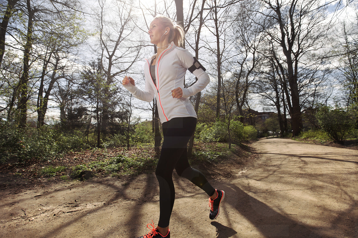 Fit female model jogging in forest – Jacob Lund Photography Store ...