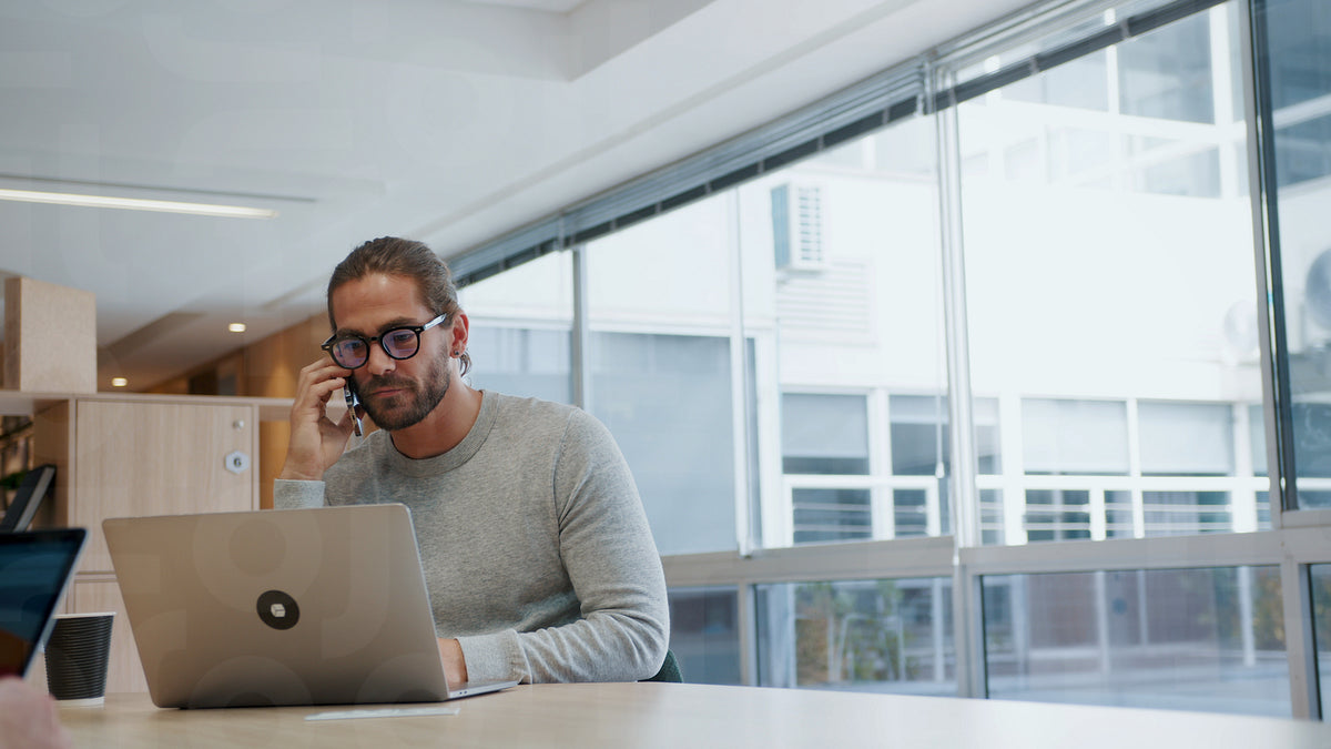 Male professional making business phone calls in a coworking space ...