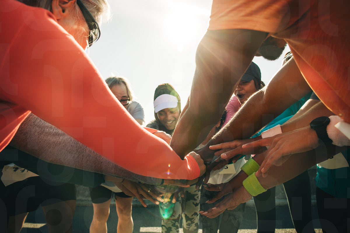 Group of runners huddling with hands united before a race – Jacob Lund ...