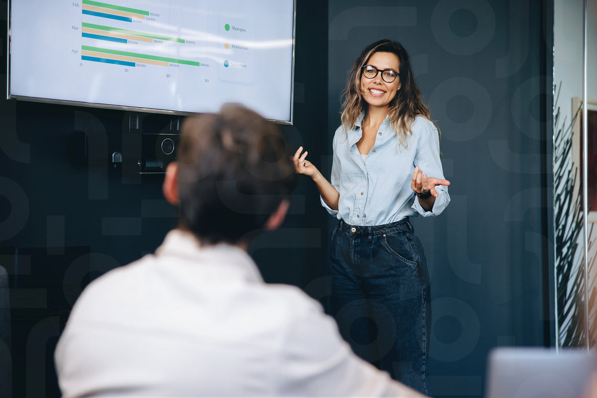 Female marketing professional delivering a presentation during a meeti ...