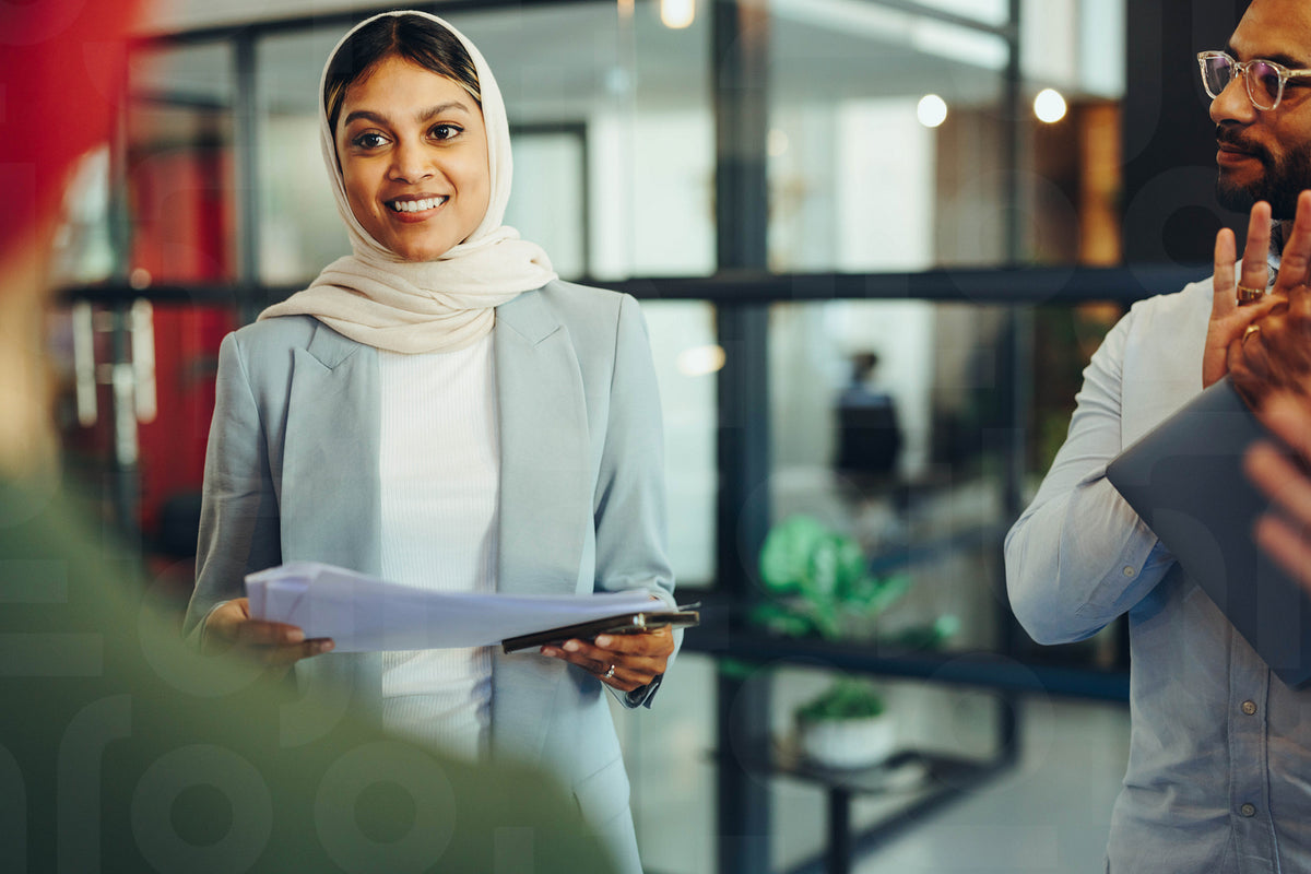 Cheerful Muslim manager holding a business meeting with her team ...