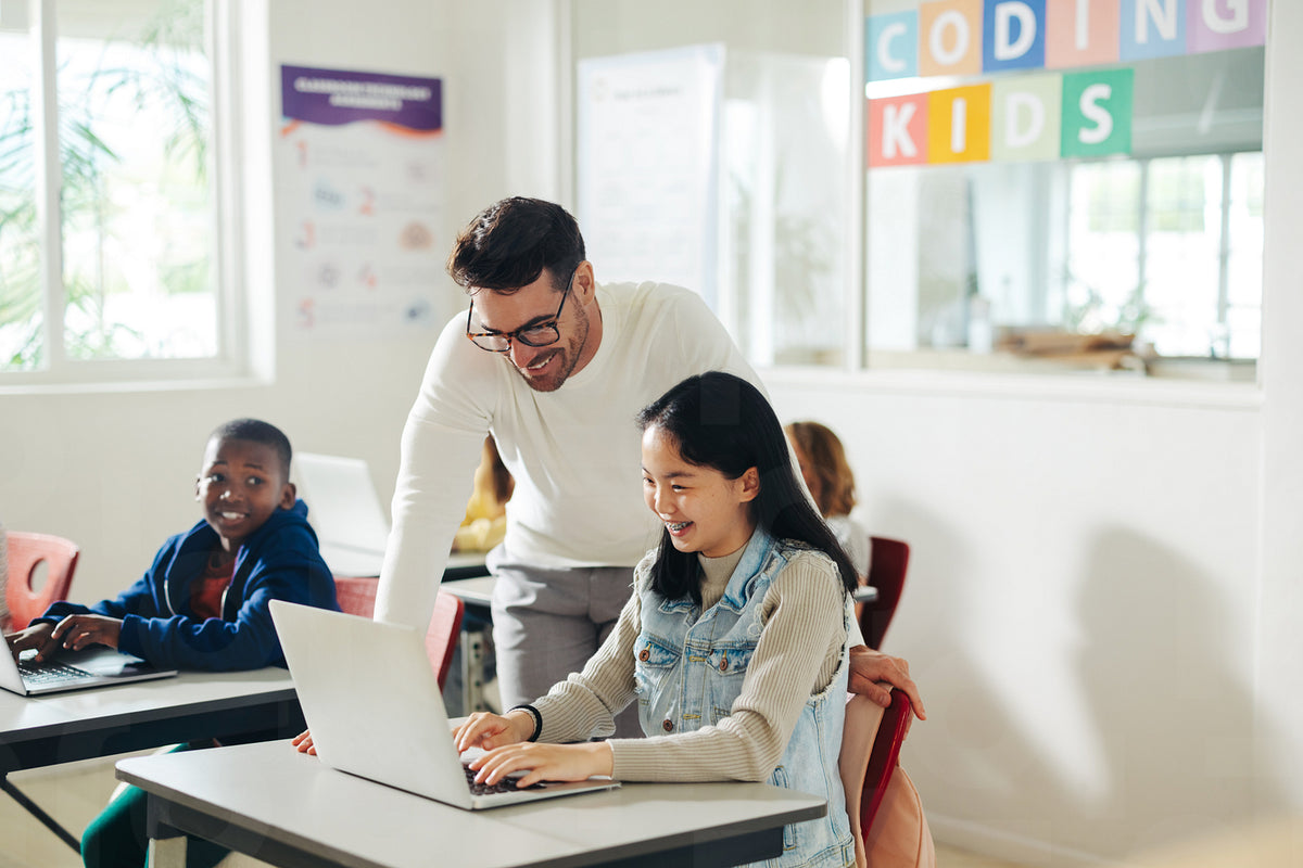 Coding class: Teacher guiding student with computer-based learning ...