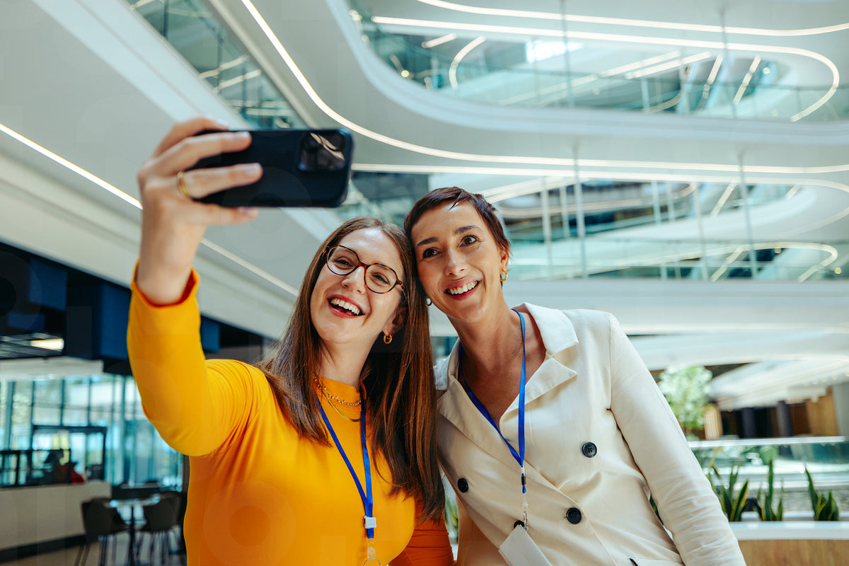 Two business women posing for a selfie, capturing a professional yet r ...