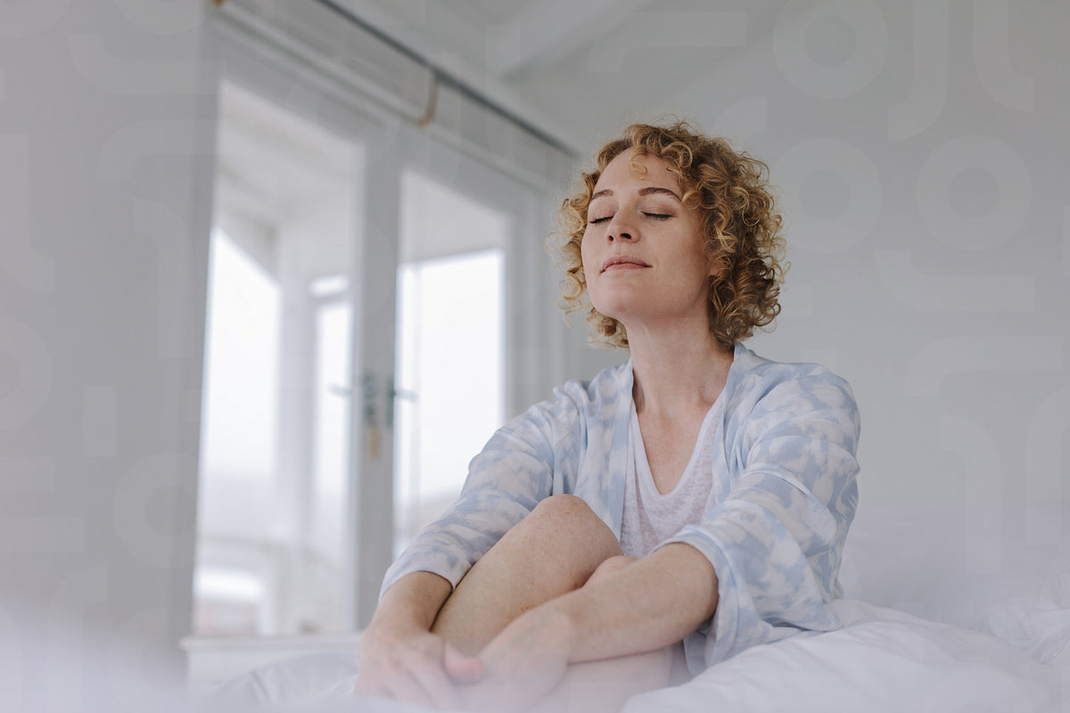 Woman sitting on bed after waking up – Jacob Lund Photography Store ...