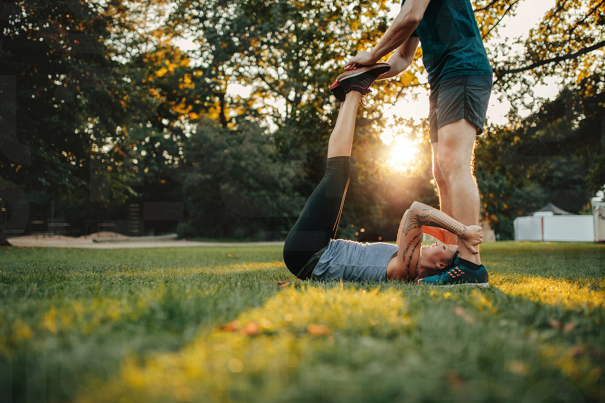Personal trainer assisting woman in leg stretching workout – Jacob Lund ...