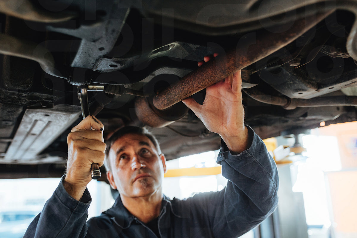 Mechanic working under a lifted car – Jacob Lund Photography Store ...