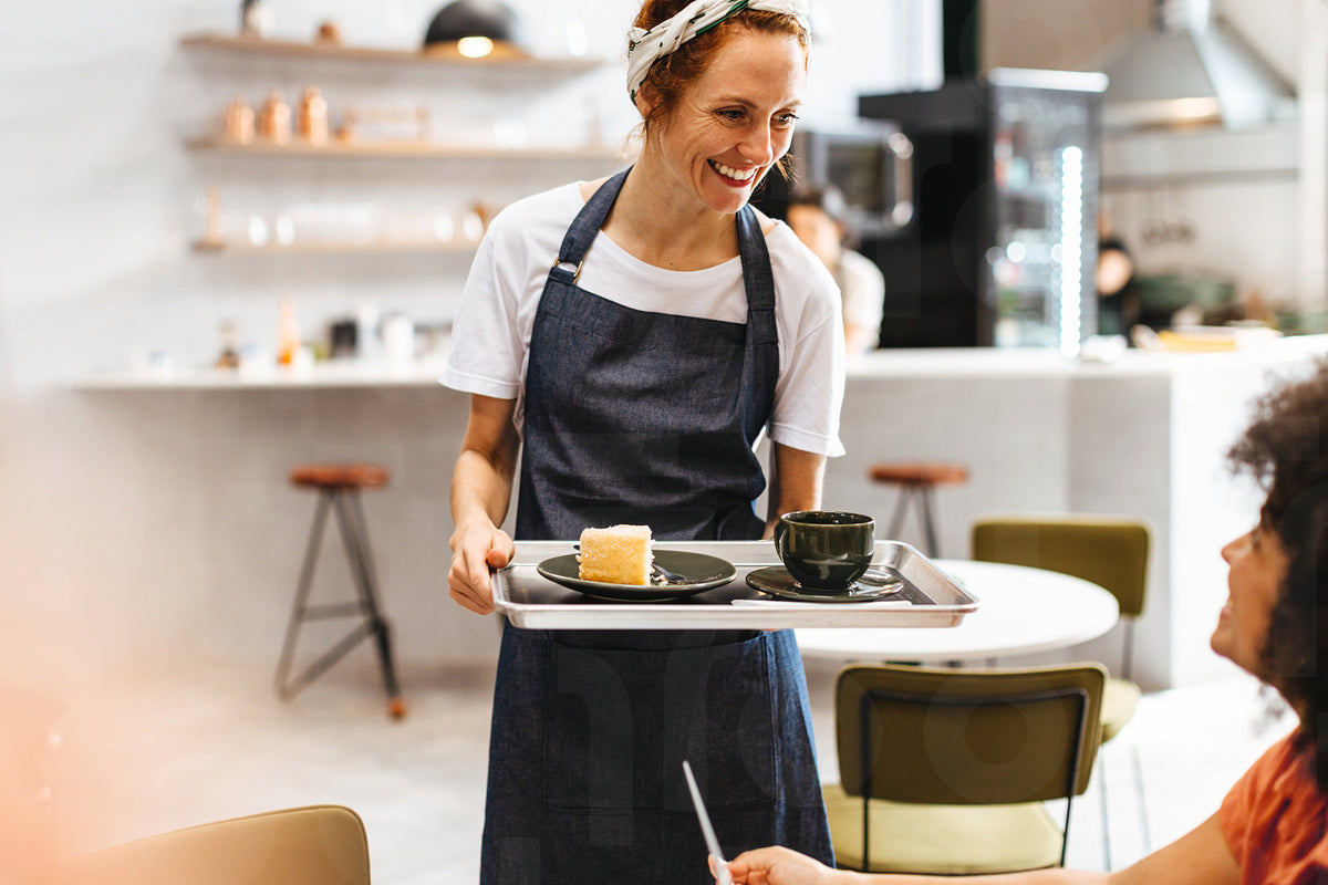 Female barista serving coffee and cake on a tray – Jacob Lund ...