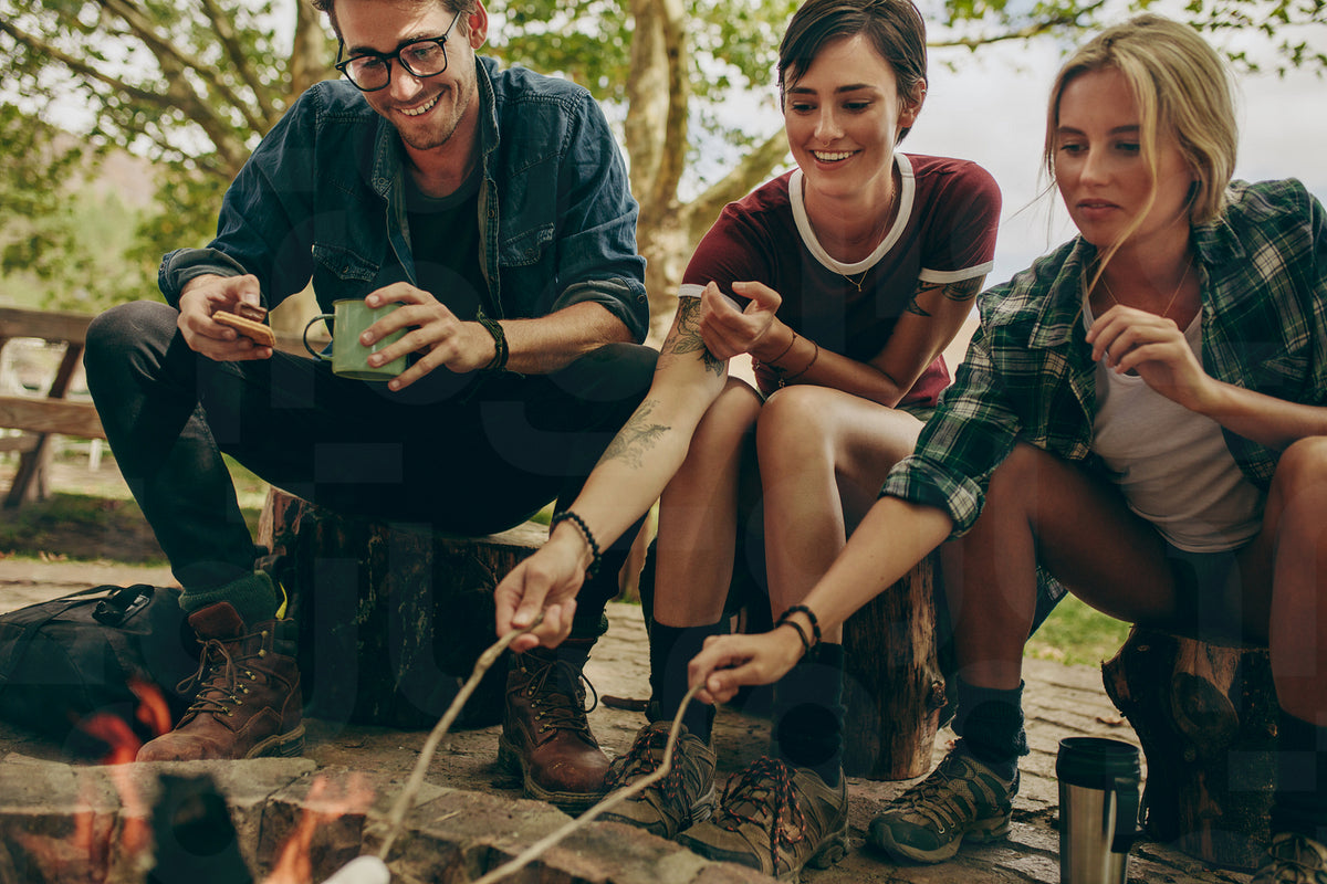 Friends toasting food on bonfire in the countryside – Jacob Lund ...