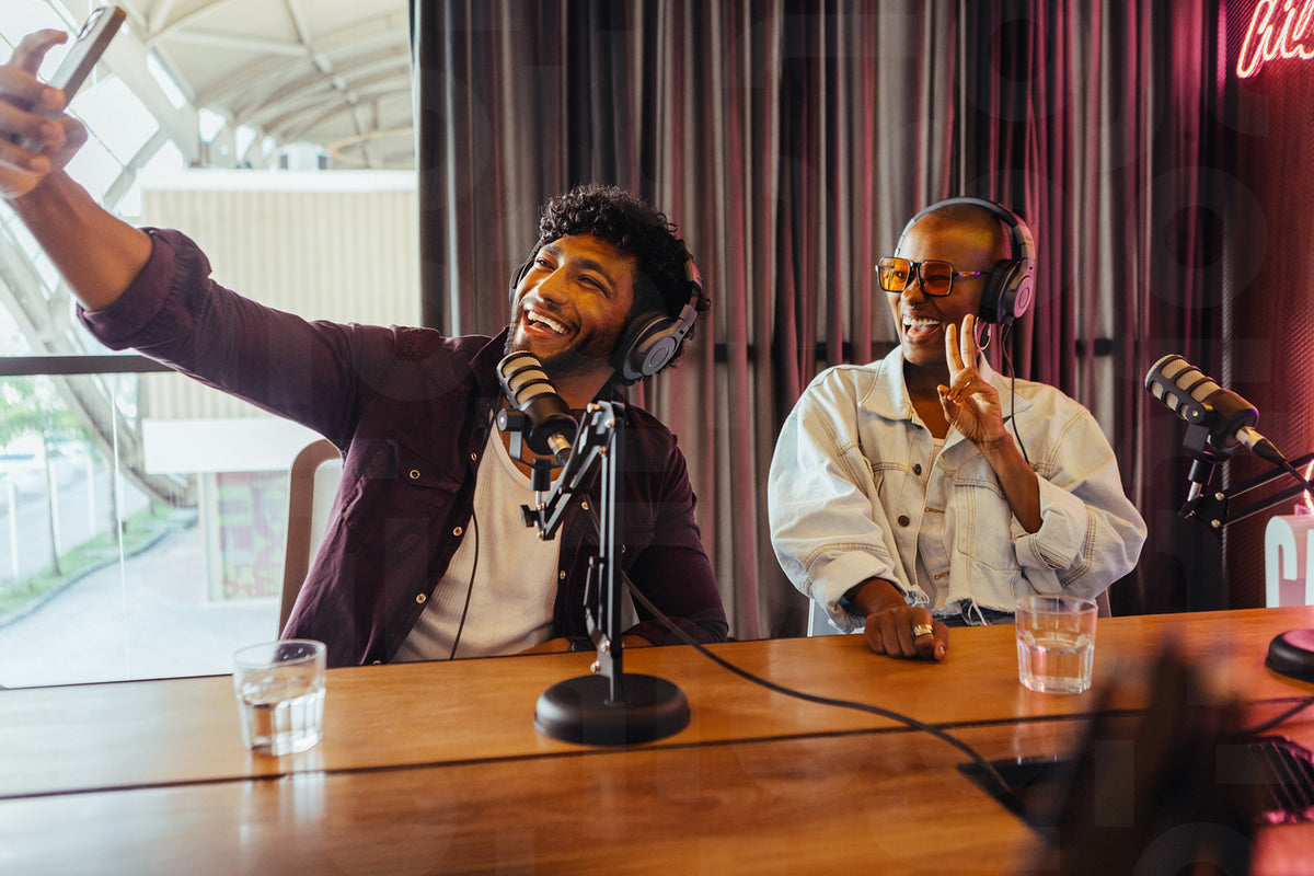 Podcast hosts enjoying live session, taking selfie, studio environment ...