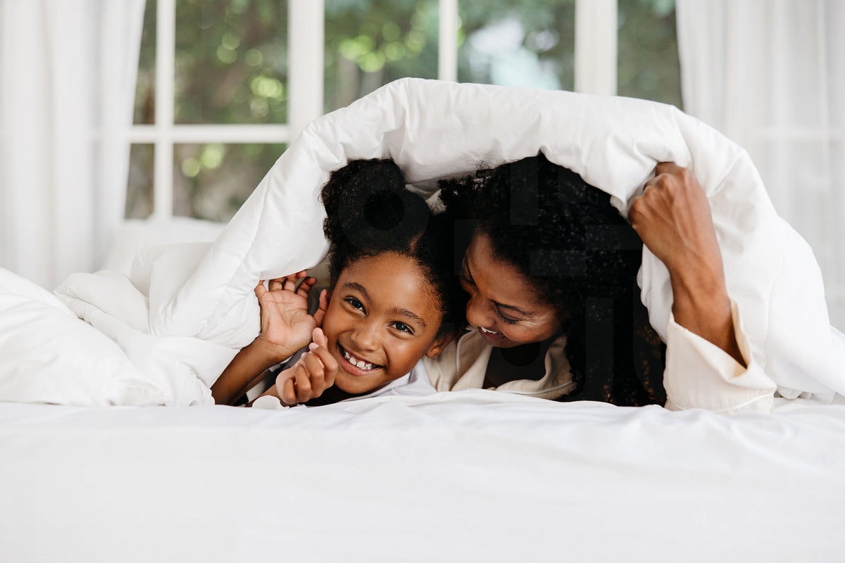 Joyful mother and daughter playing under blanket – Jacob Lund ...