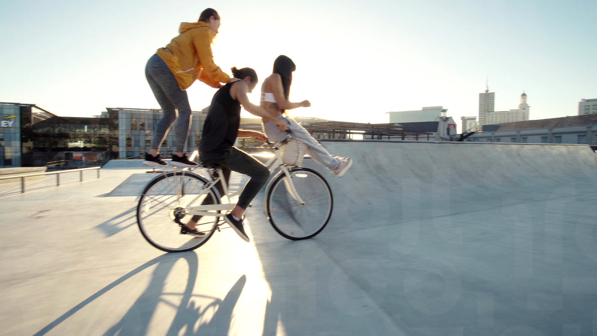 Playful friends riding a bicycle together in a skate park – Jacob Lund ...