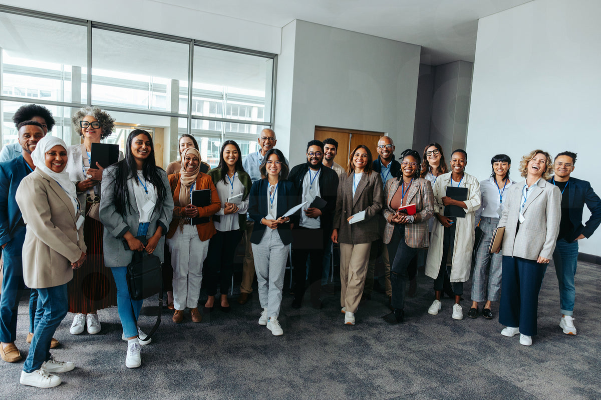 Diverse professional team posing happily at a seminar event indoors ...