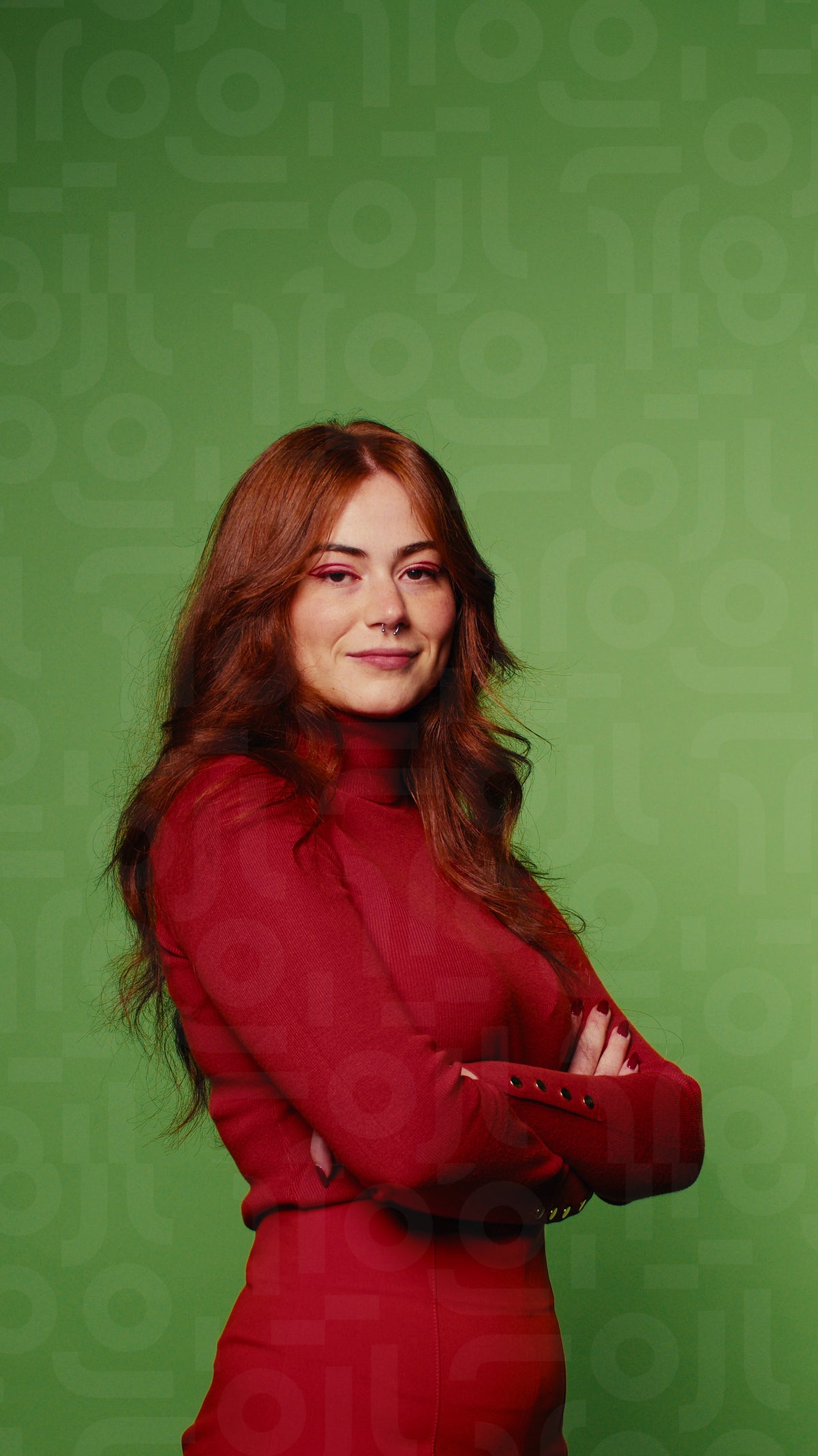 Happy young woman with long brown hair and red turtleneck dress on gre ...