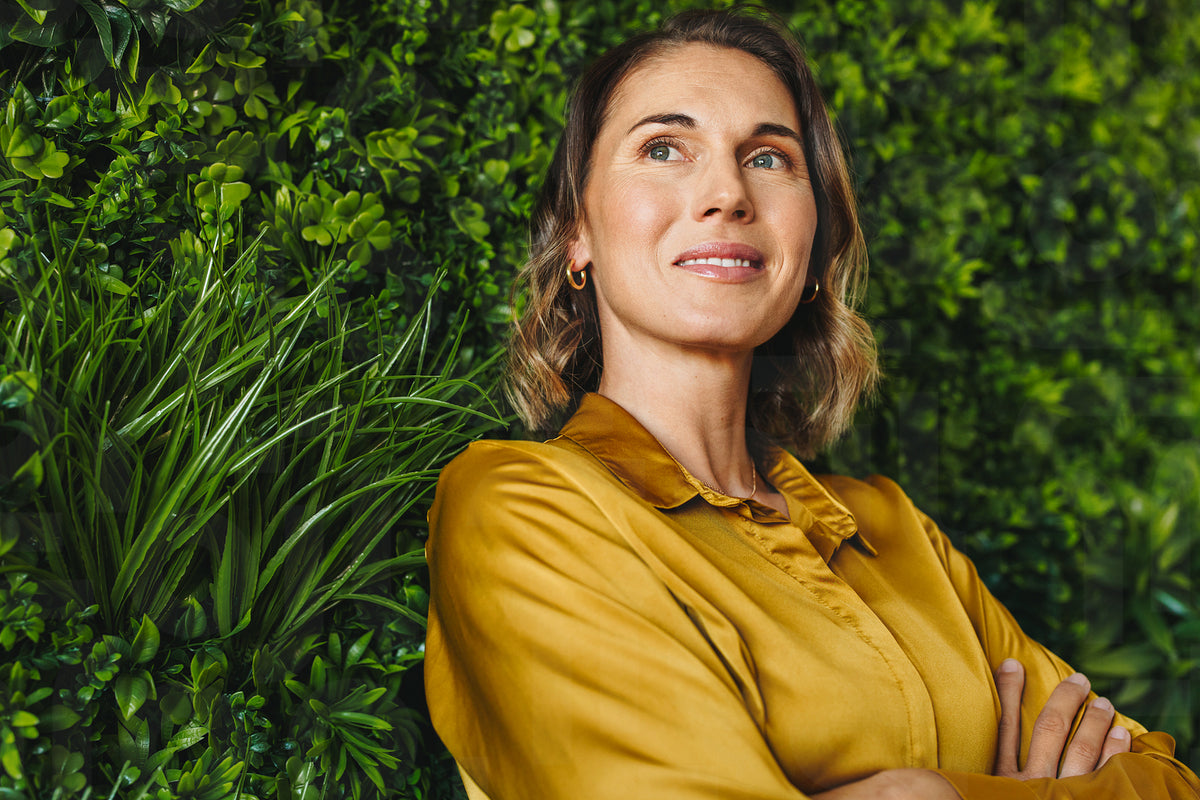 Think sustainability: Female company owner standing in a green office ...