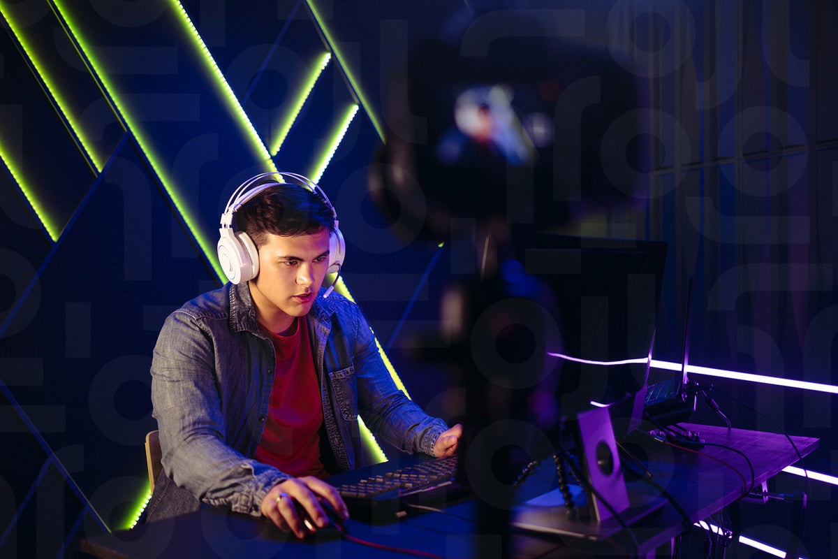 Male gaming influencer live streaming himself playing a video game ...