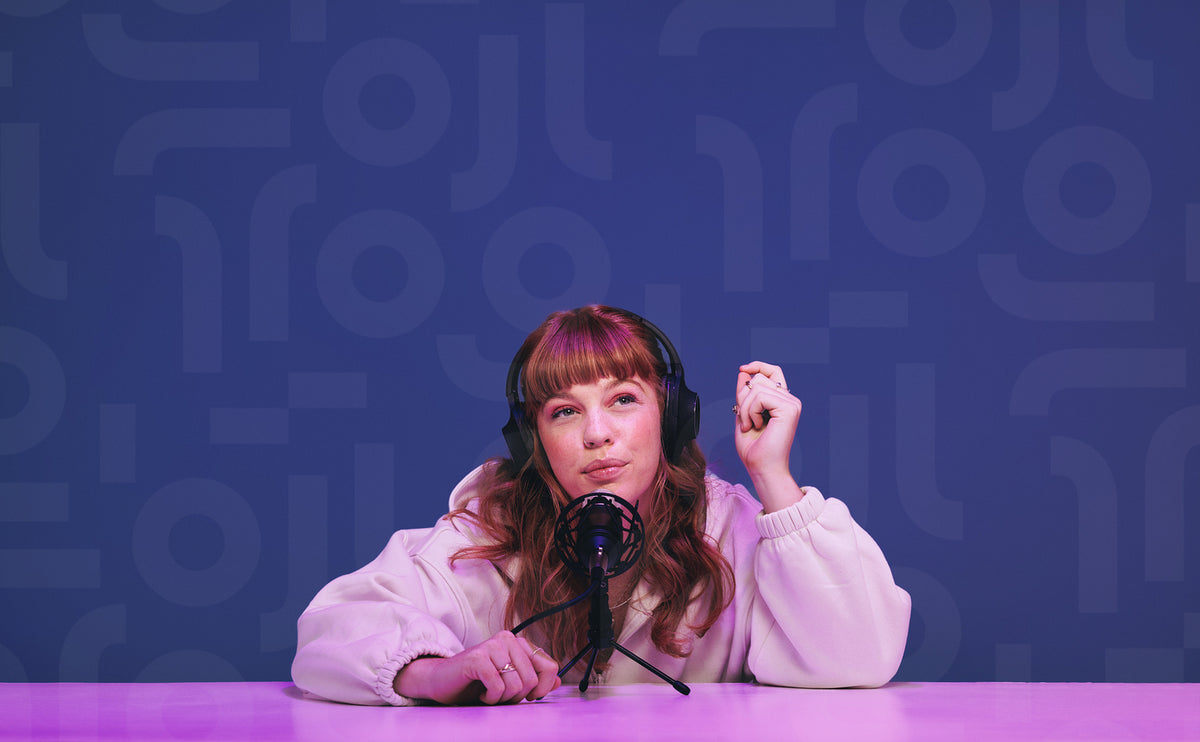 Woman with ginger hair whispering into a microphone while recording an ...