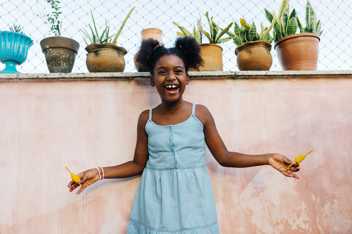 Happy Afro-Brazilian girl enjoying picolés, frozen fruit popsicles ...