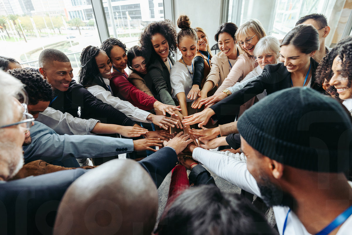 Corporate team with hands united celebrating success and teamwork in m ...