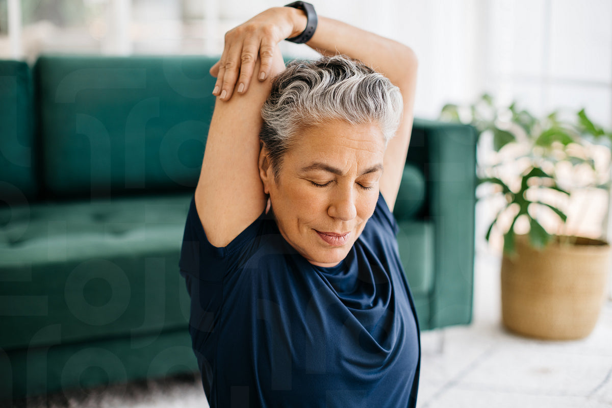 Overhead tricep stretch during yoga: Senior woman doing an arm exercis ...