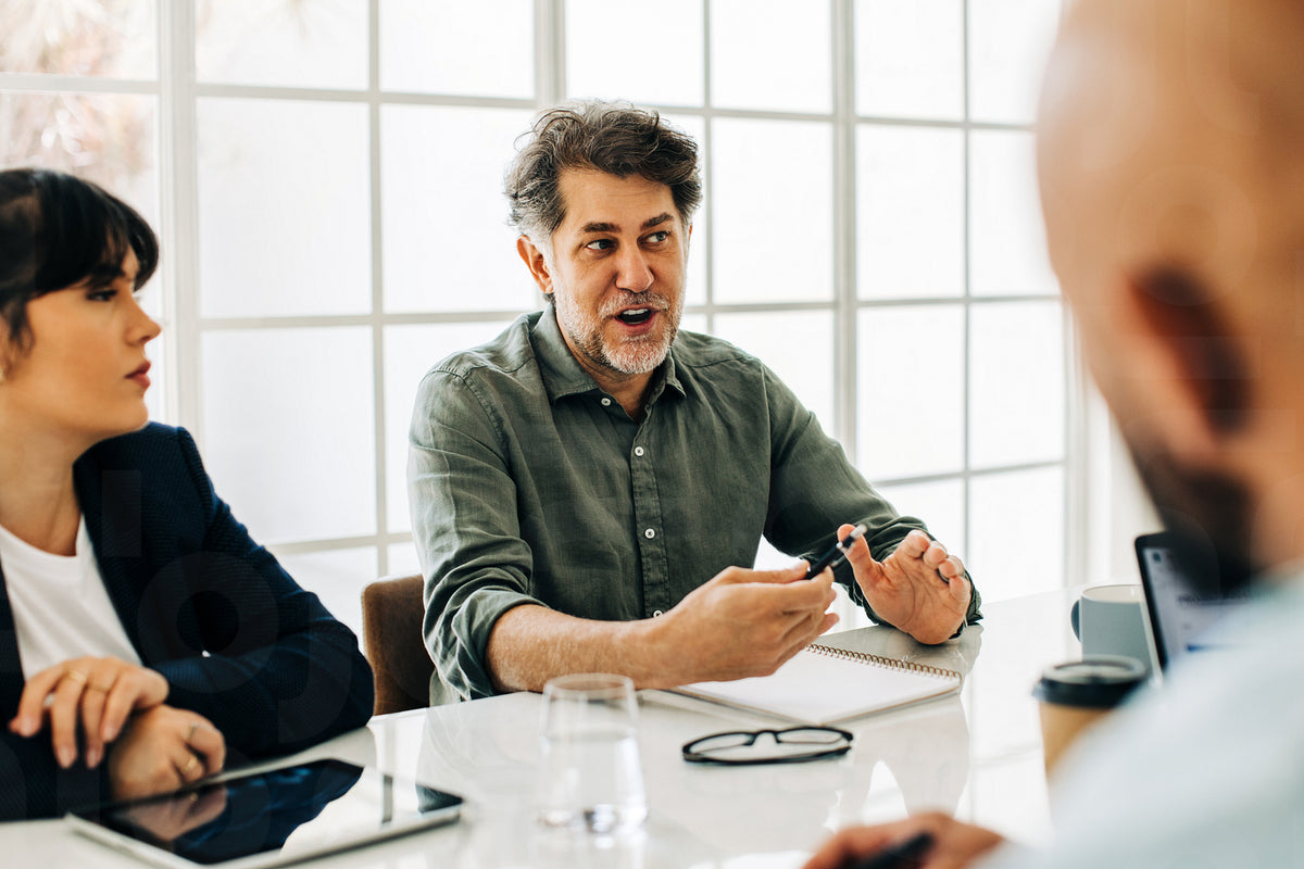 Senior business man discussing with his team, giving solutions and ide ...
