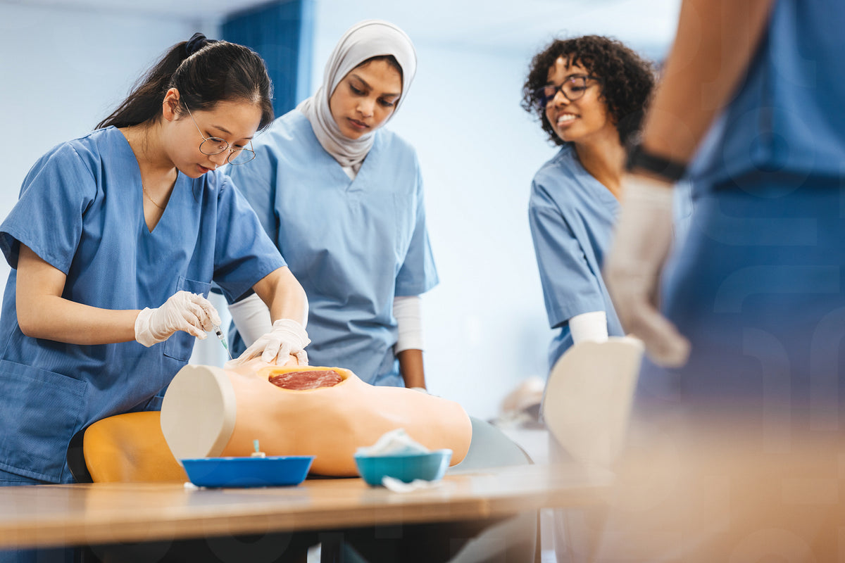 Female nursing students getting injection training in simulation centr ...
