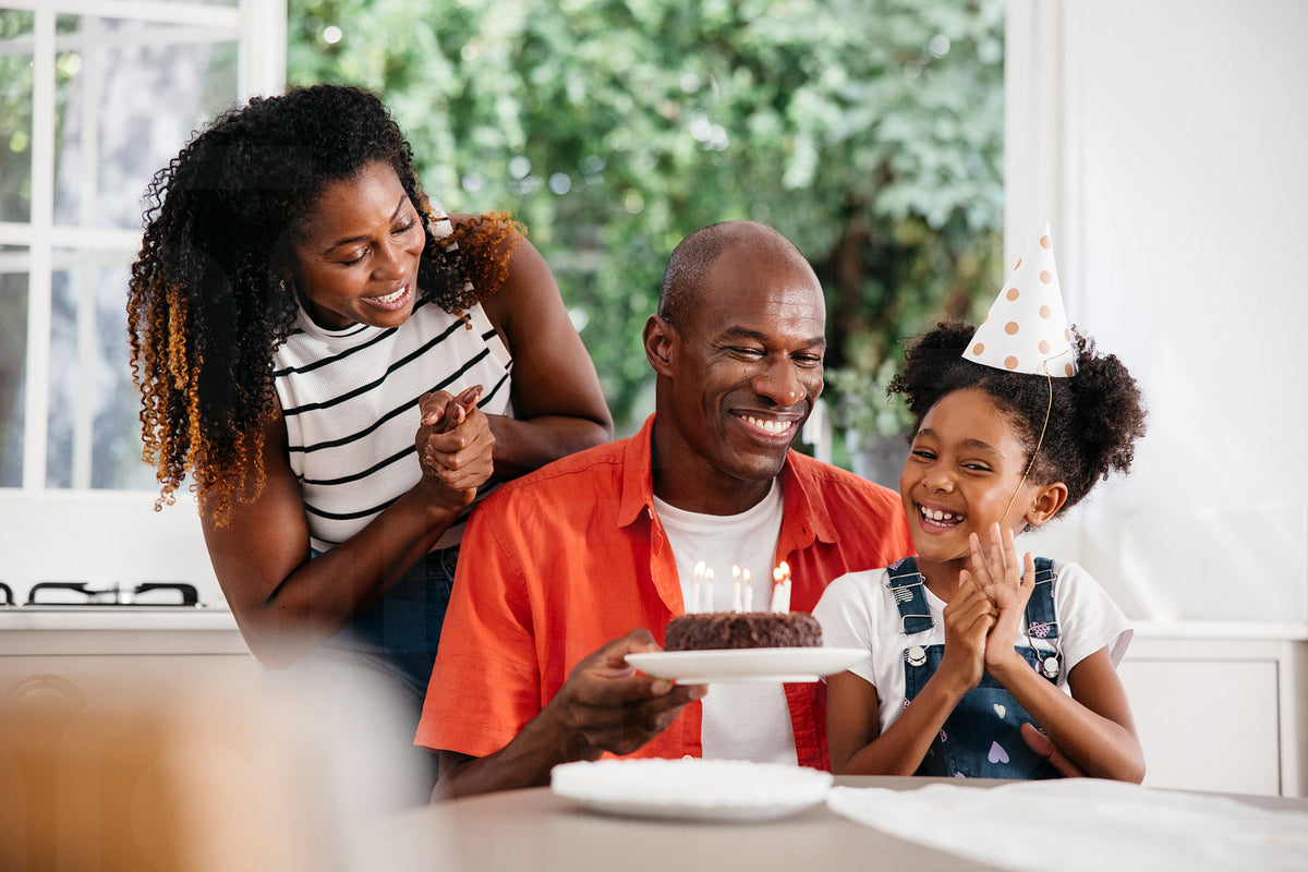 Birthday party - Family celebrating young daughter's birthday with cak ...