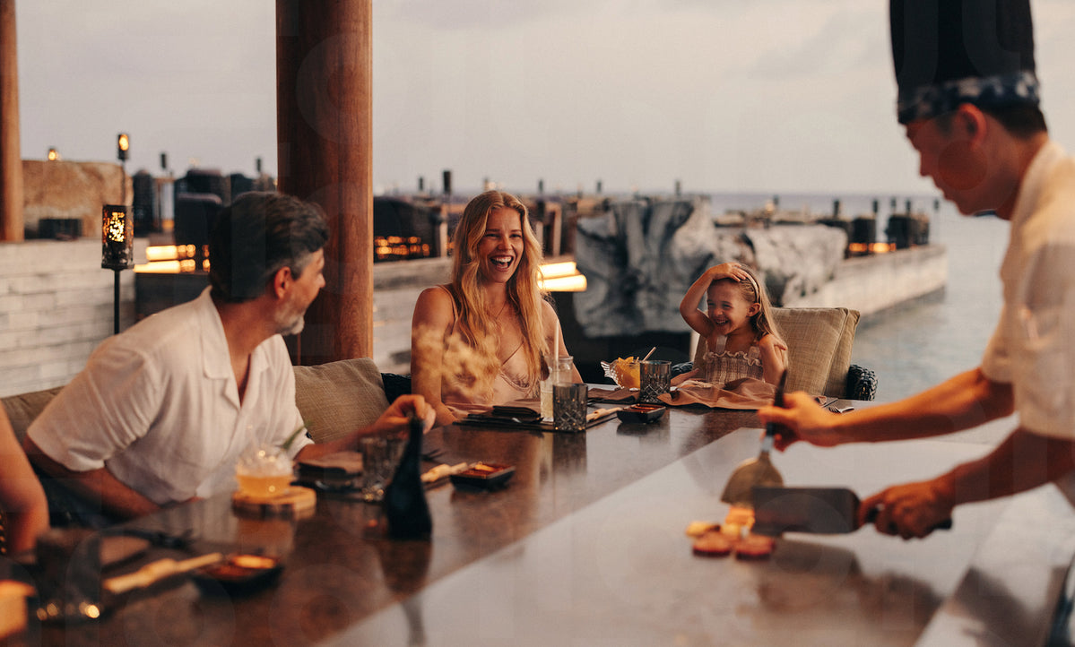 Family enjoying teppanyaki dinner at a seaside gourmet restaurant ...