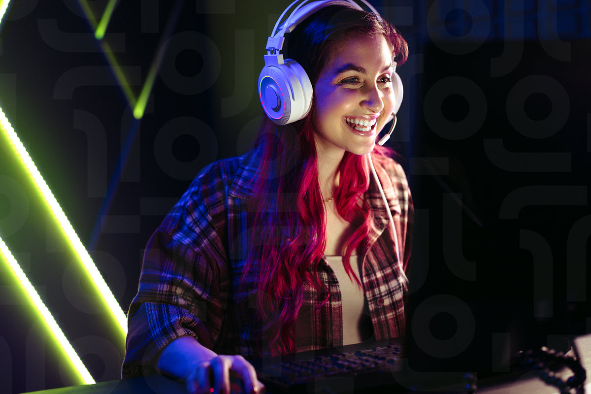 Female gamer smiling at her screen as she dominates a virtual game ...