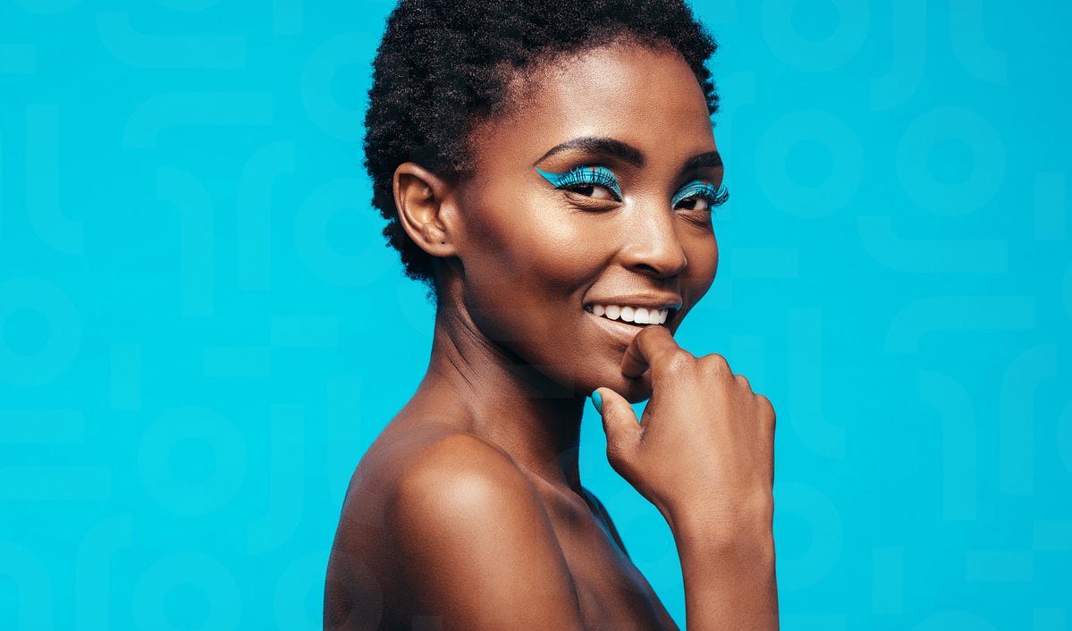 Woman with makeup smiling against blue background – Jacob Lund ...