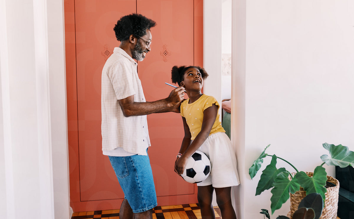 Excited about growing taller: Little girl looking at her height measur ...
