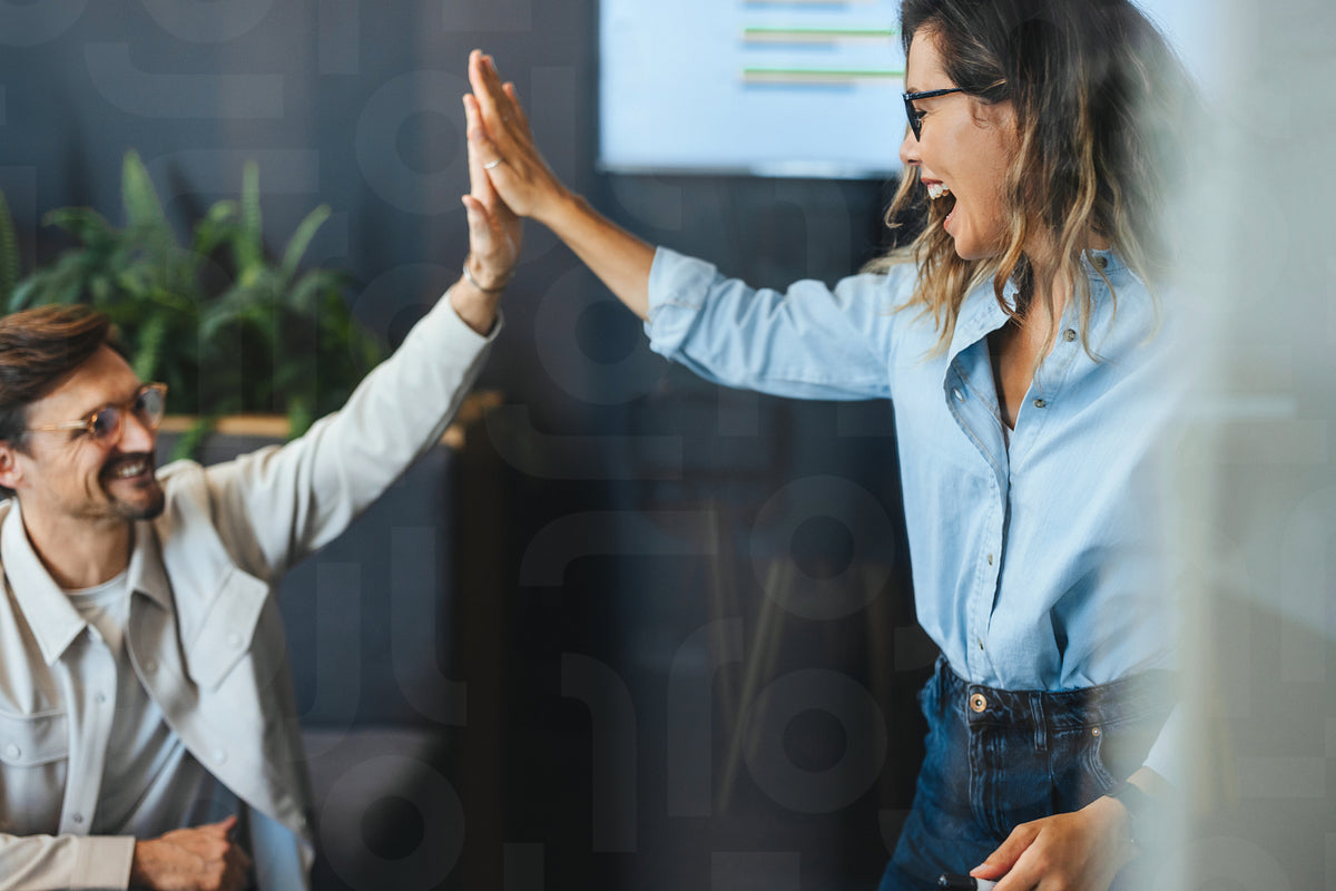Business colleagues high fiving each other, celebrating teamwork and s ...