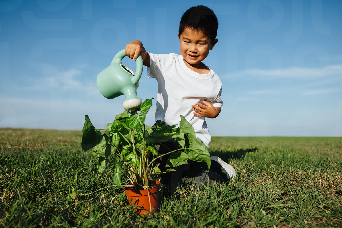 Boy watering plant outdoors shows growth care joy – Jacob Lund ...