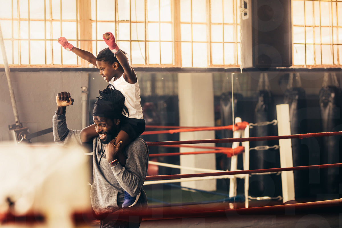 Kid sitting on shoulders of boxing coach celebrating a win – Jacob Lund ...